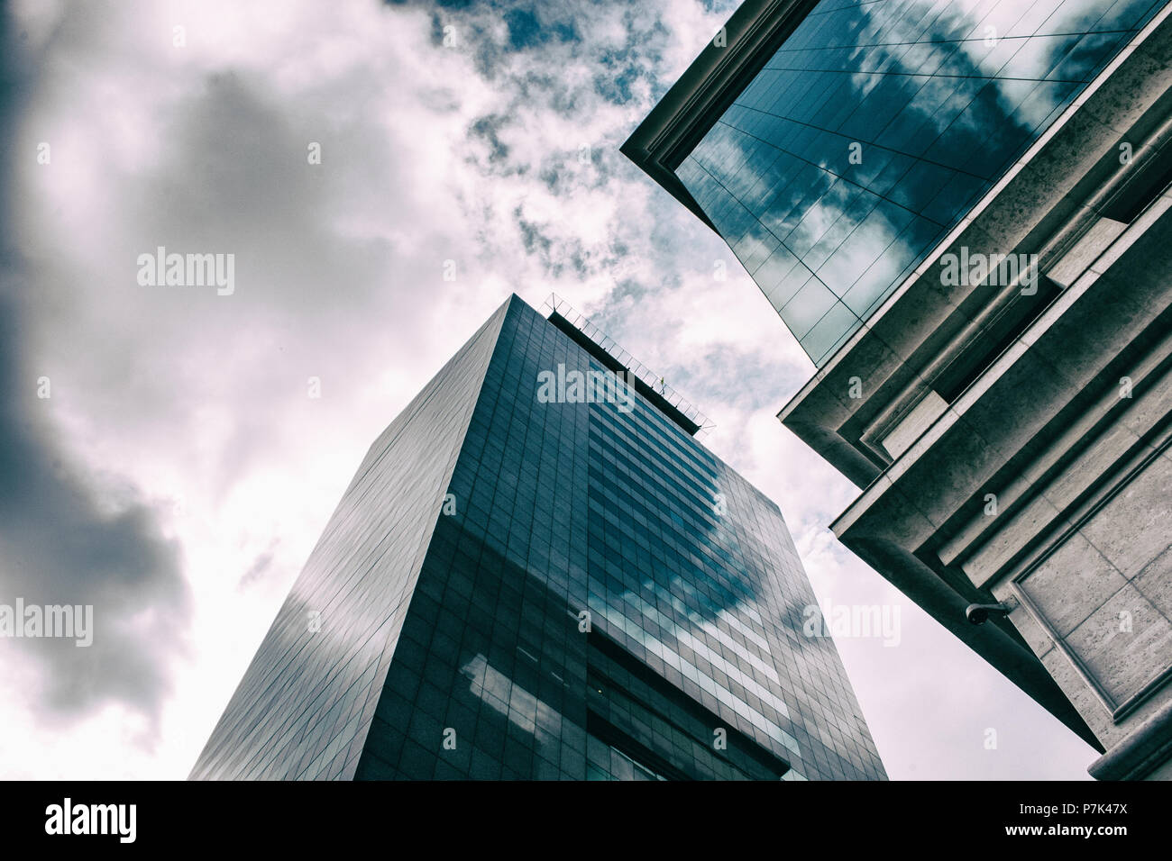 White clouds are reflected in the windows of business buildings made of ...