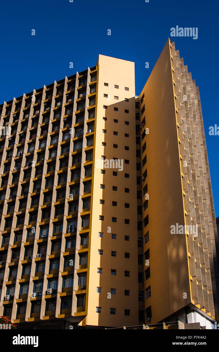 An old office yellow building with unusual shape with clear blue sky ...