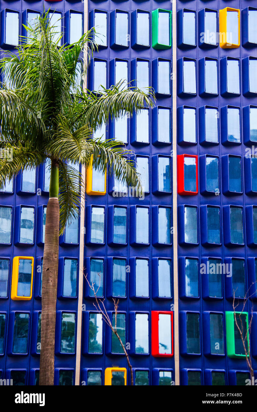 Modern architecture blue building with colorful windows and a palm tree ...