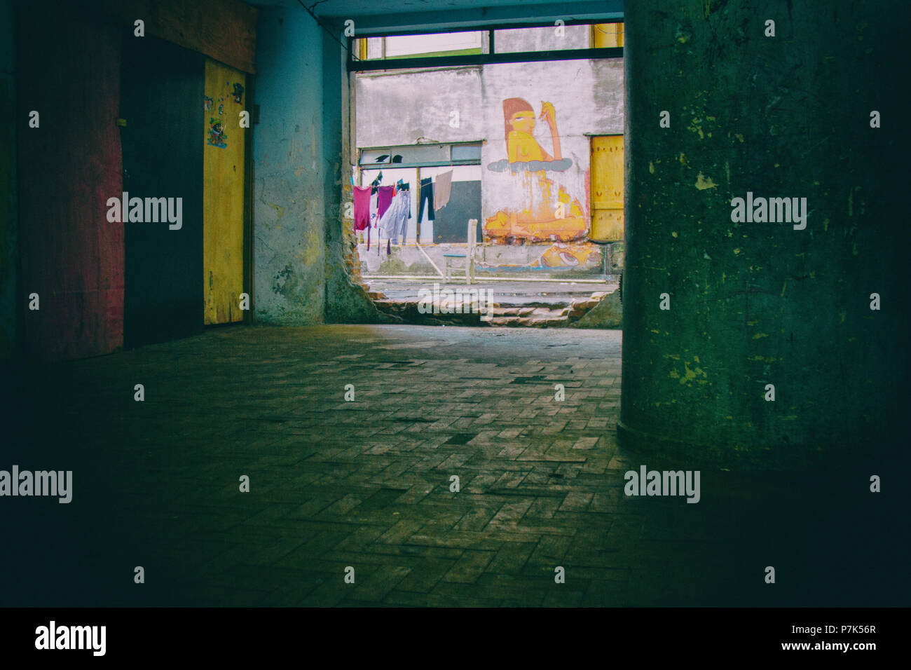 Decayed walls painted in an eroded building occupied by social housing ...