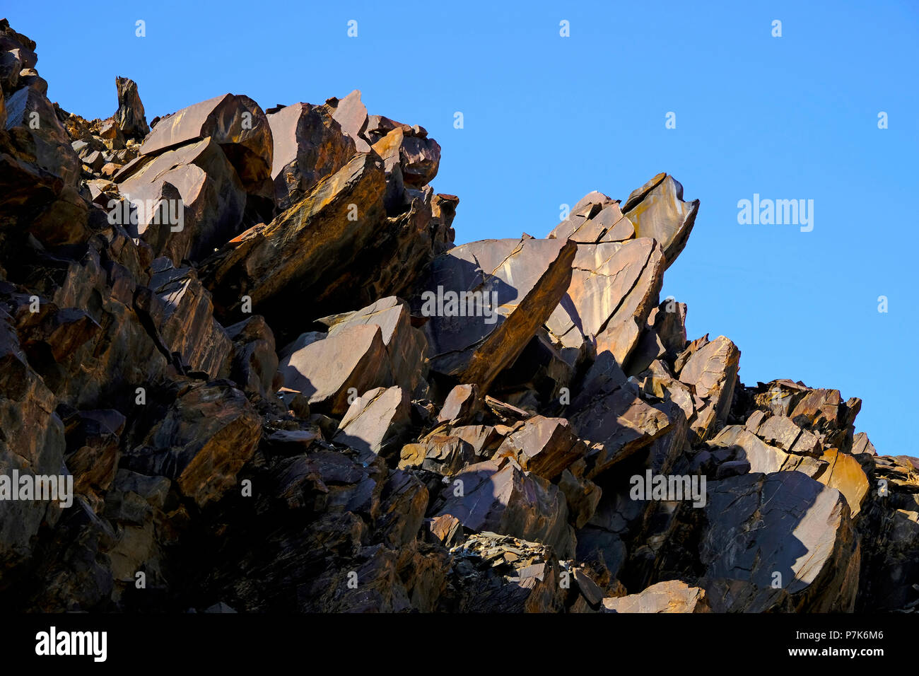 detail of a wildly ragged sandstone rock with smooth, coloured failure ...