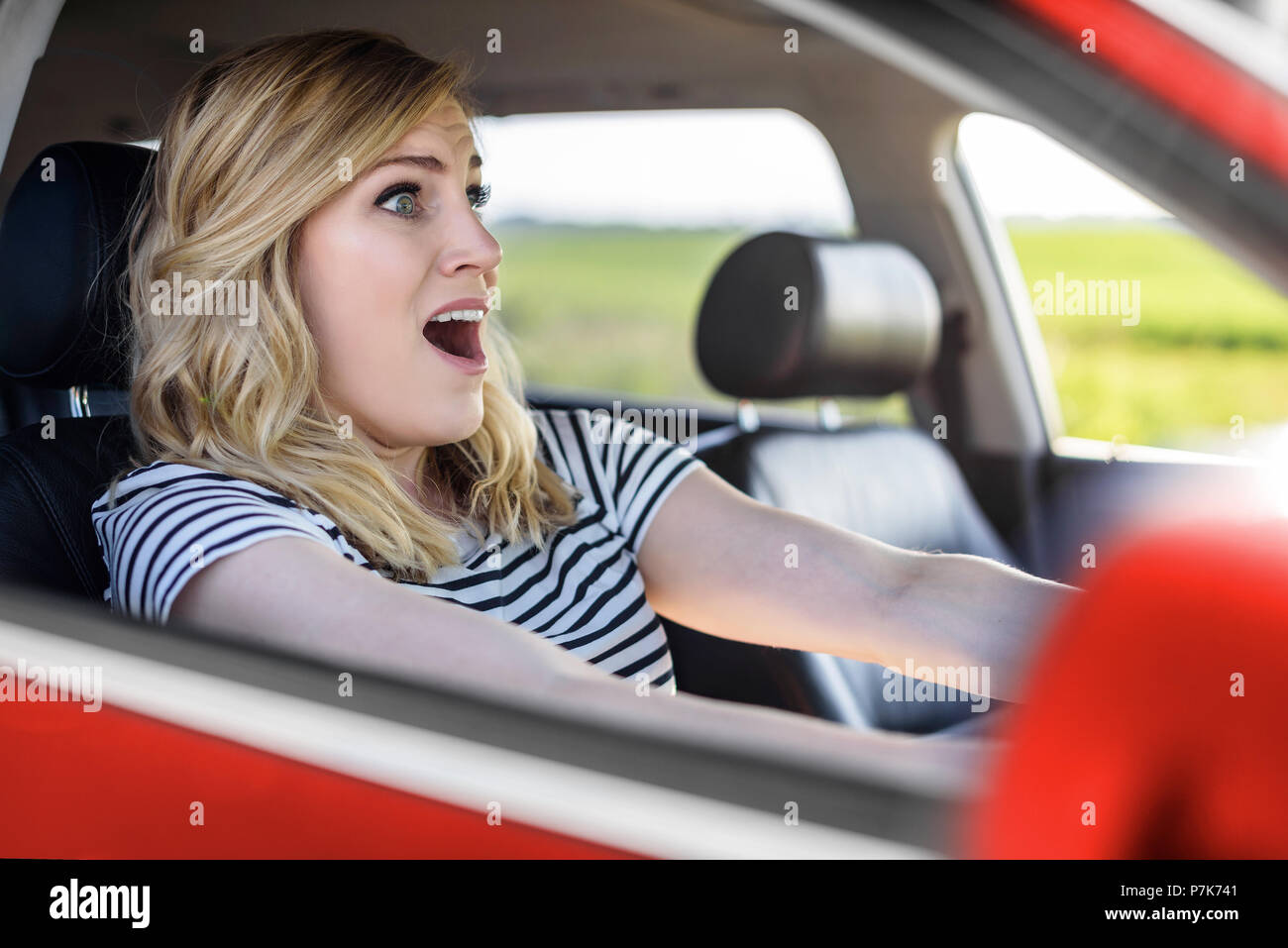 The woman driving the car in a panic Stock Photo - Alamy