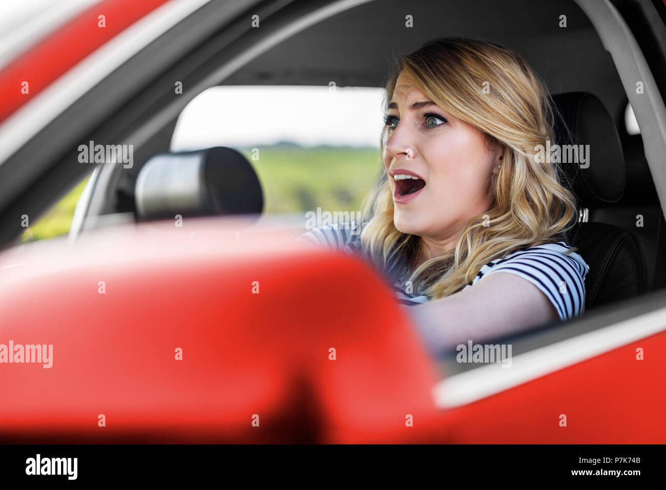 The woman driving the car in a panic Stock Photo - Alamy