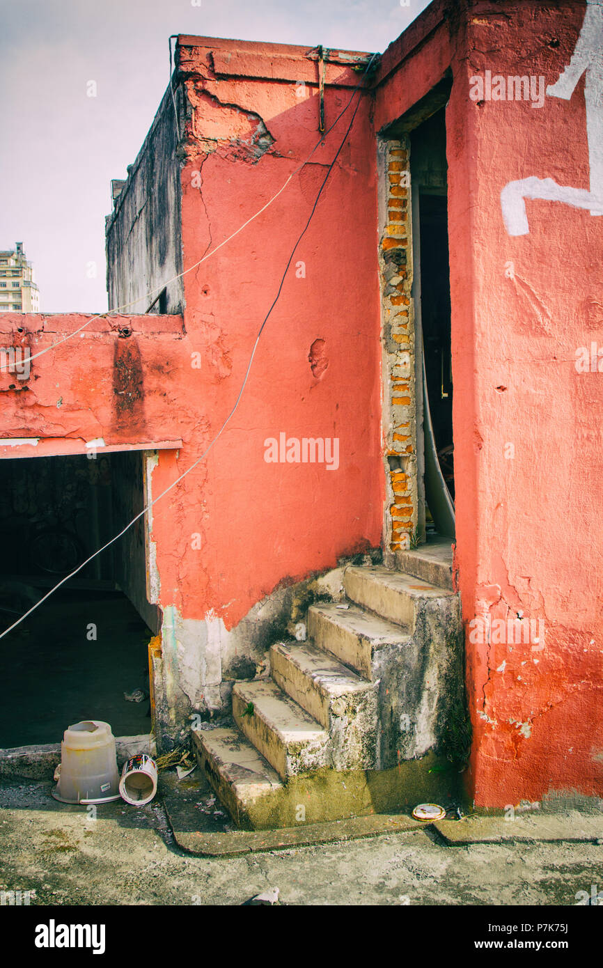 Worn construction with red walls and the number 1 painted in white with ...
