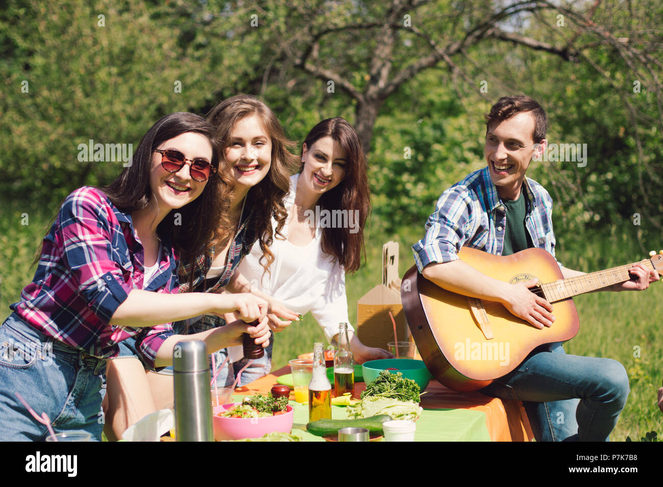 Group of friends having picnic in park Stock Photo - Alamy