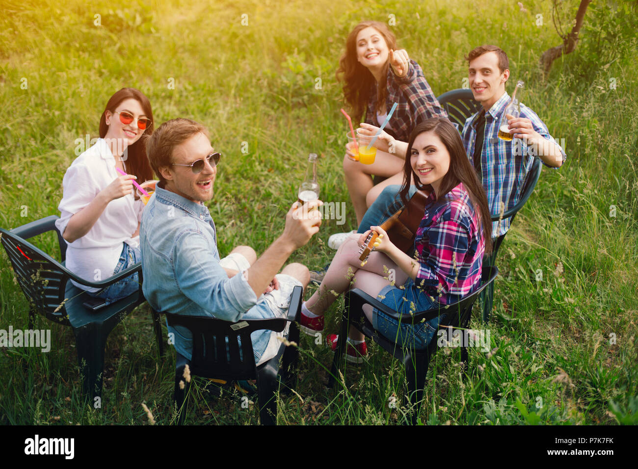 Group of friends having picnic in park Stock Photo - Alamy