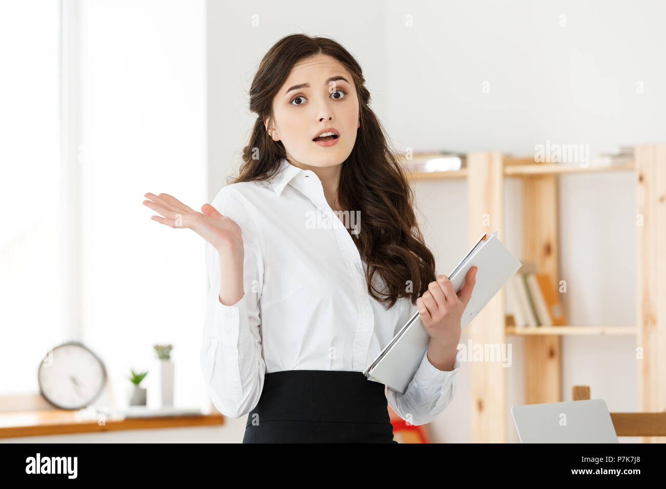 Shocked young business woman surprised by reading unexpected news in ...