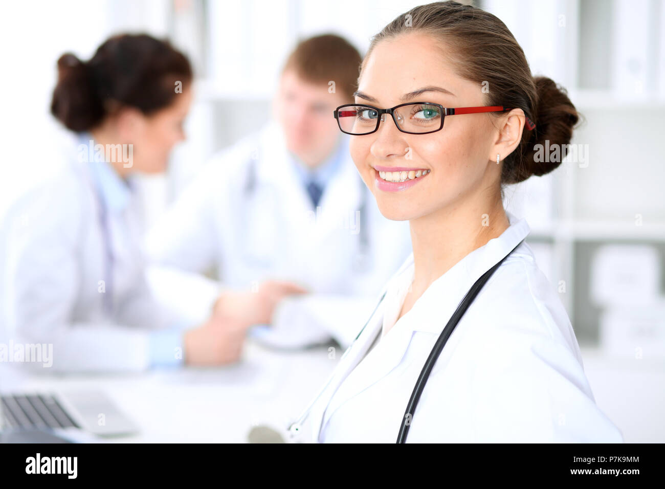 Female doctor working with medical staff at hospital. Teamwork in ...