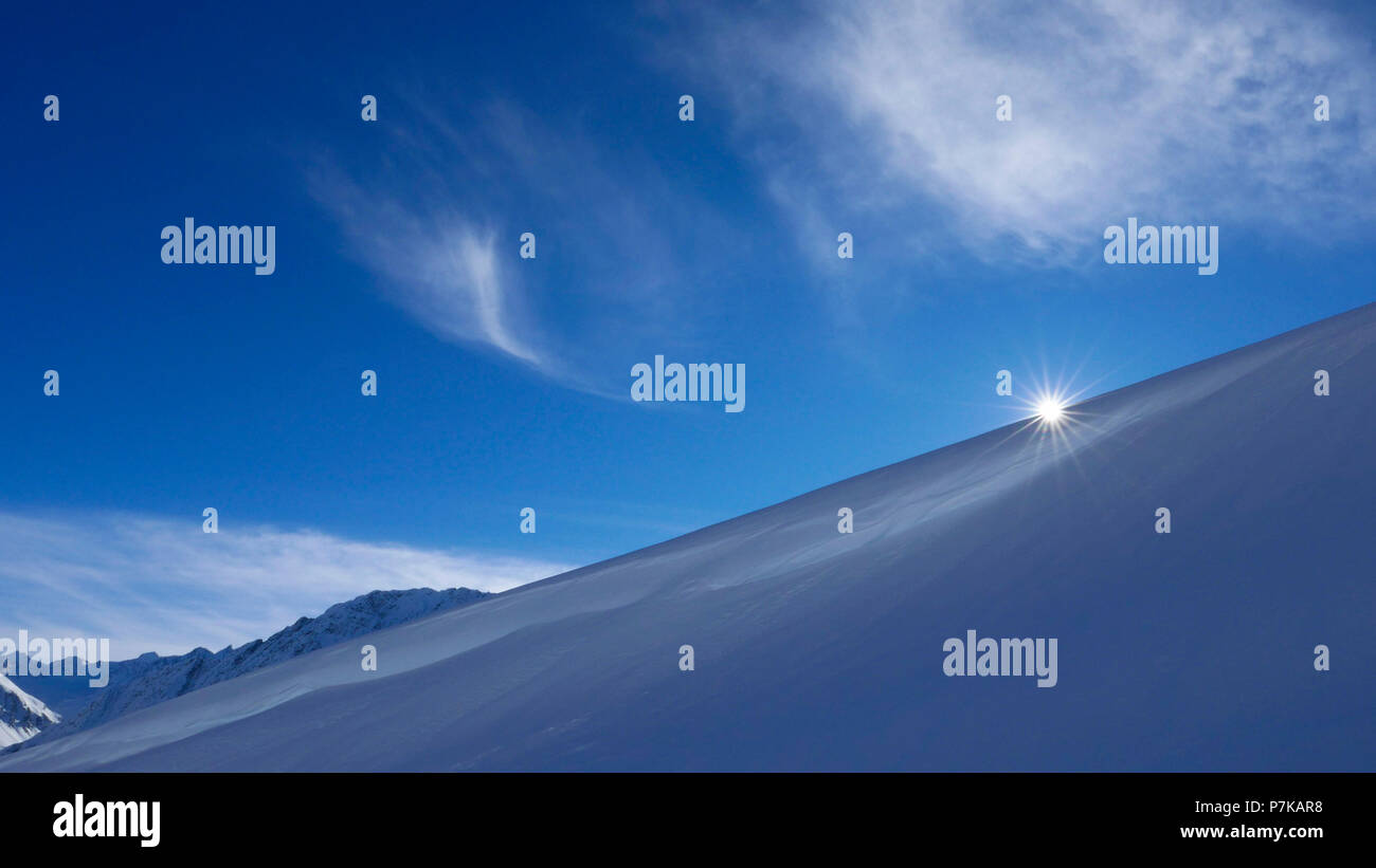 Sun star over snow rodge with drift, Cirrus and Cirrostratus, Tyrol ...
