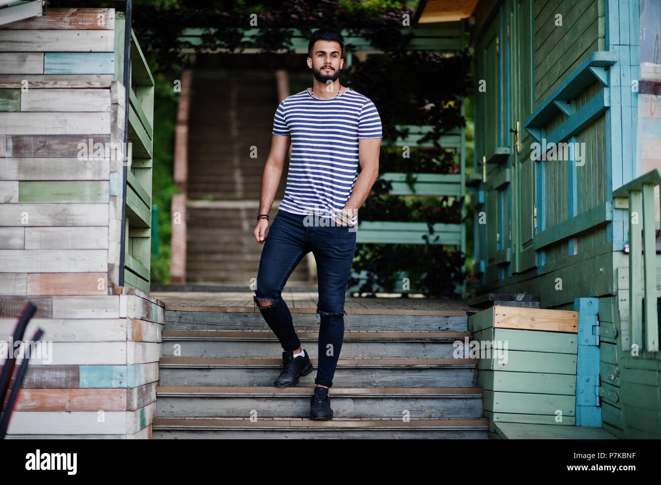 Handsome tall arabian beard man model at stripped shirt posed outdoor ...