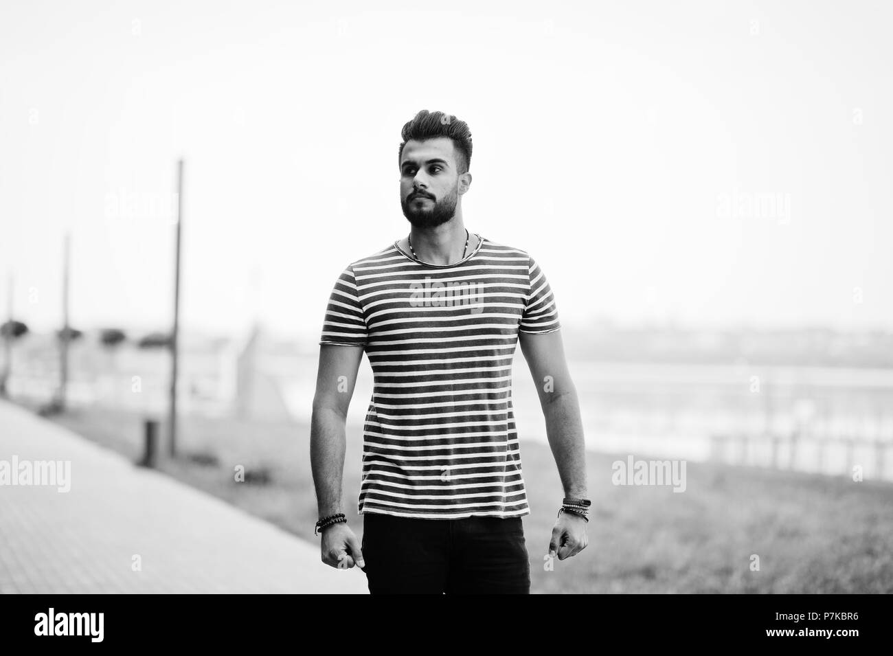 Handsome tall arabian beard man model at stripped shirt posed outdoor ...