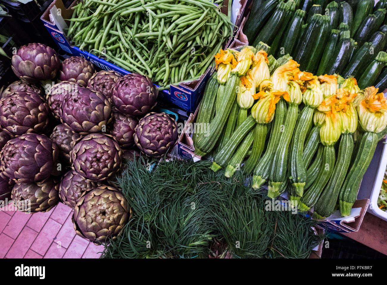Market stall with fresh agretti, artichoke, courgette flowers, cucumber ...