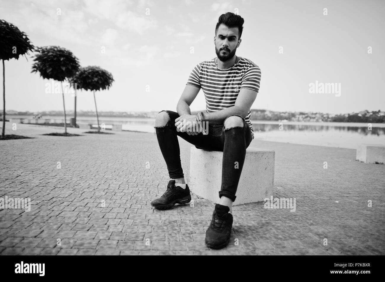 Handsome tall arabian beard man model at stripped shirt posed outdoor ...
