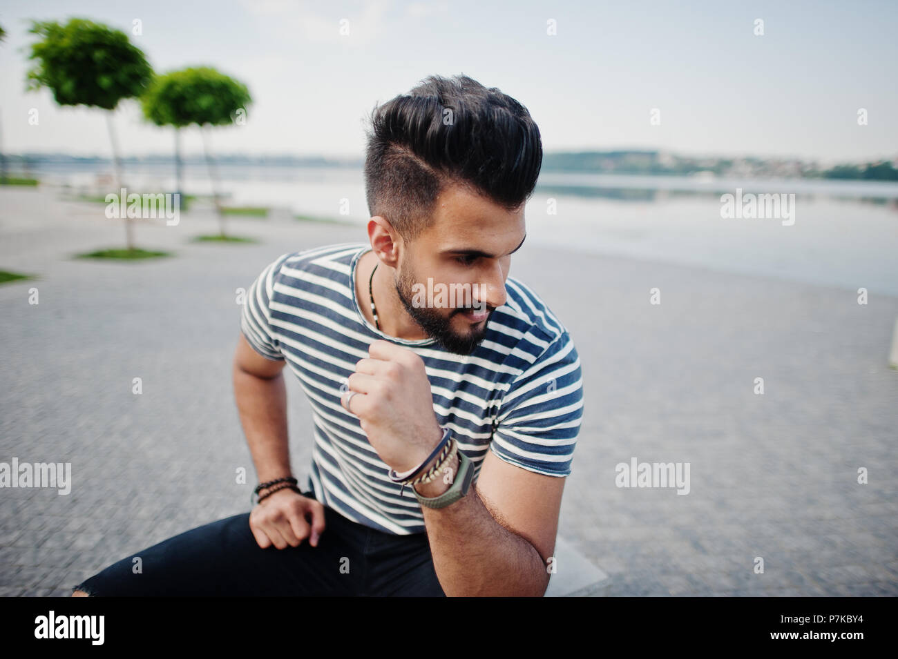 Handsome tall arabian beard man model at stripped shirt posed outdoor ...
