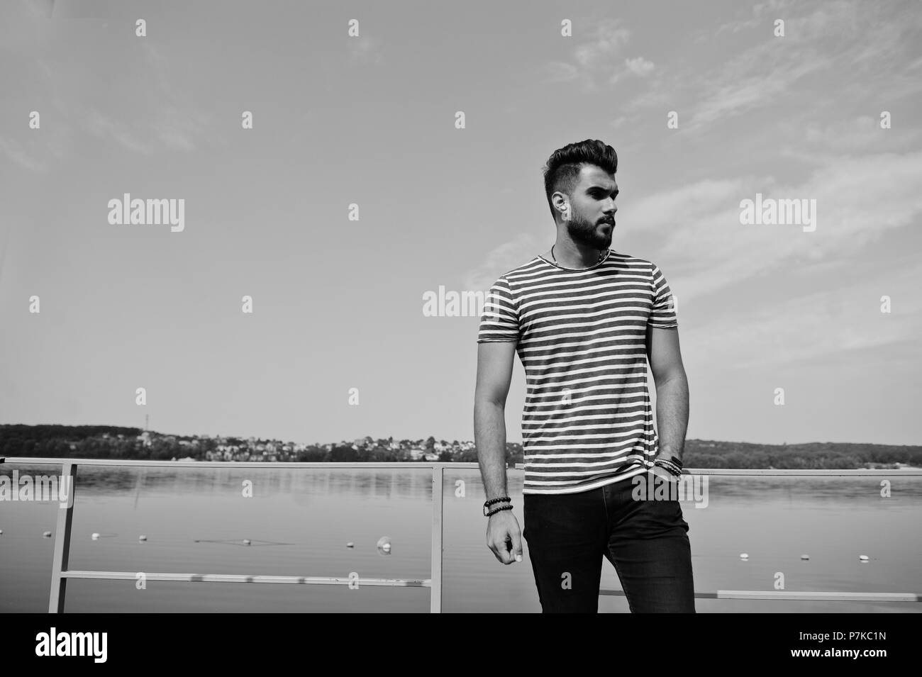 Handsome tall arabian beard man model at stripped shirt posed outdoor ...