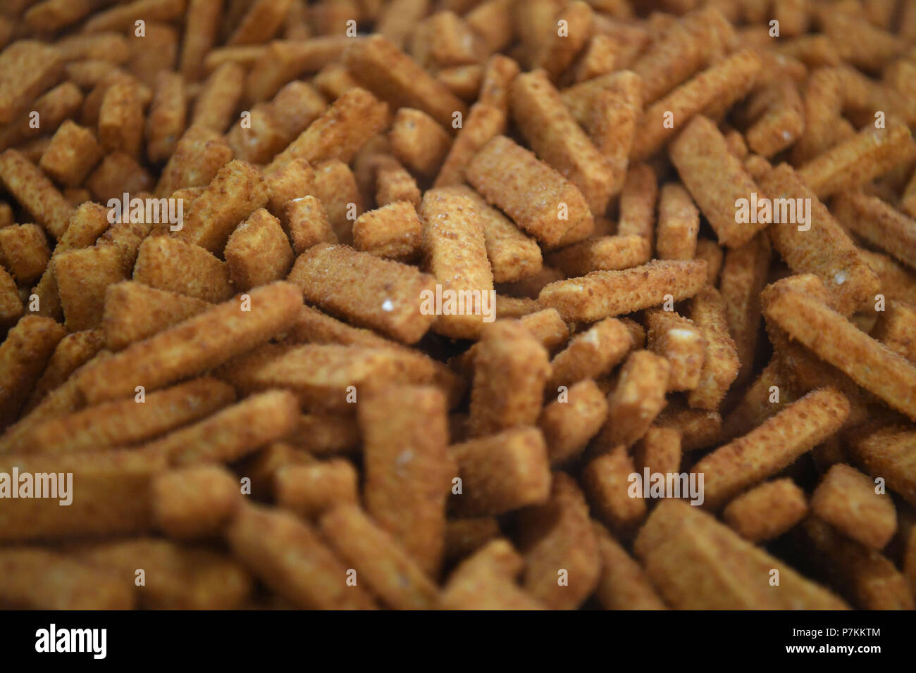 25 June 2018, Germany, Bremerhaven: Breaded fish sticks on a conveyor ...