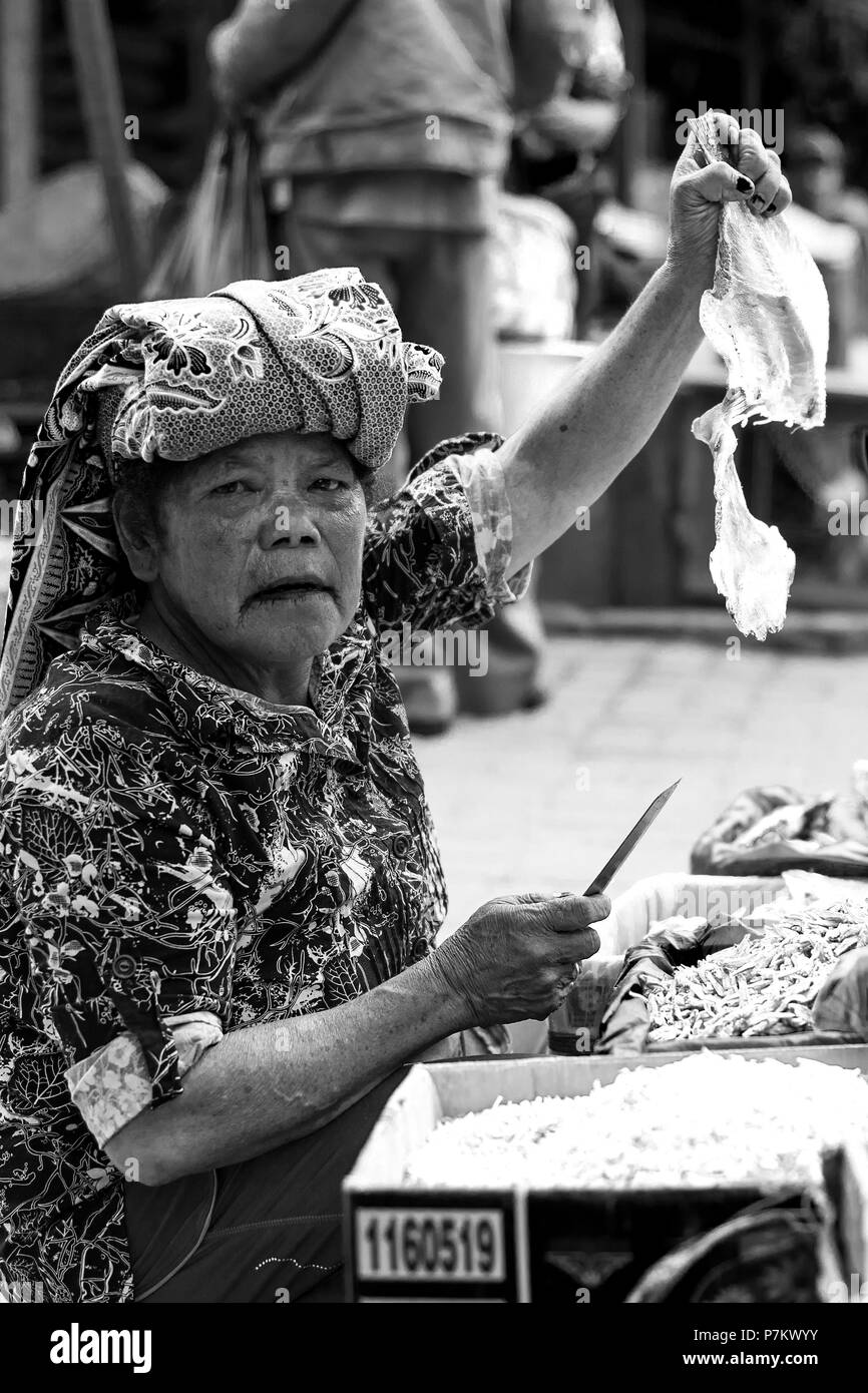Old Batak woman filleting fish in the market square of Kutacane Stock ...