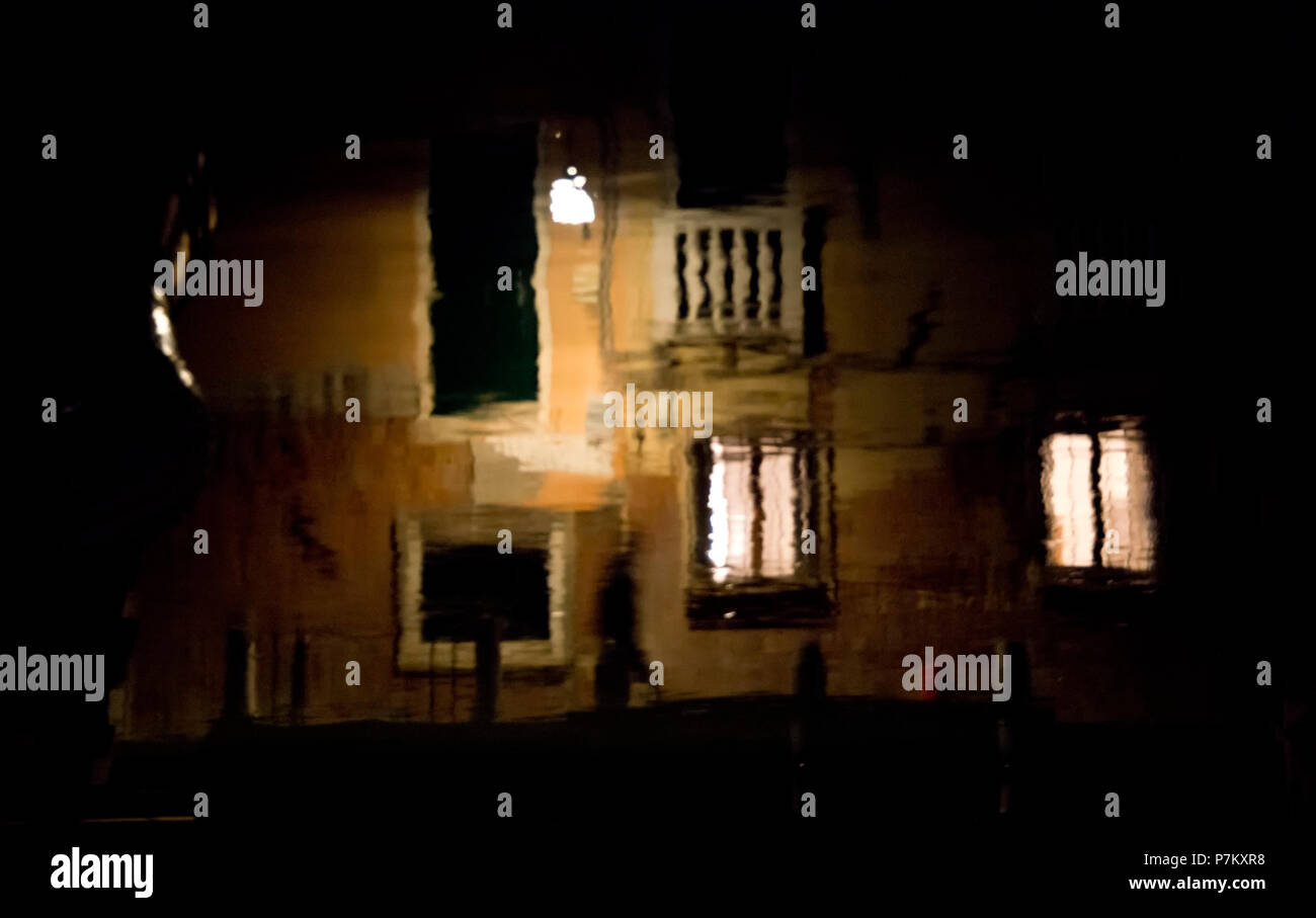 Water reflection of a house facade with man in Venice at night Stock ...