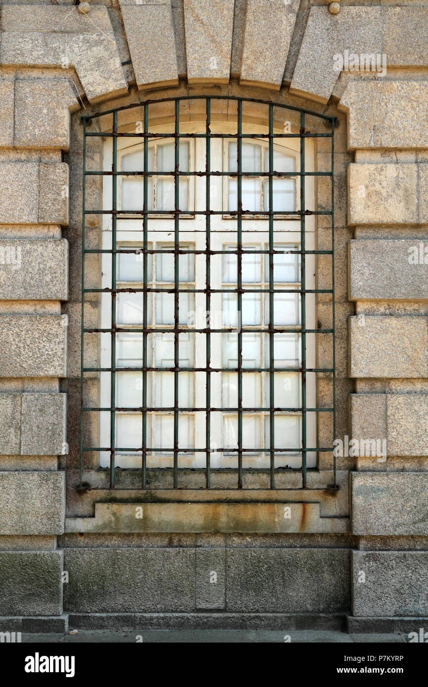 Window with metal bars of an old granite convent for women in the north ...