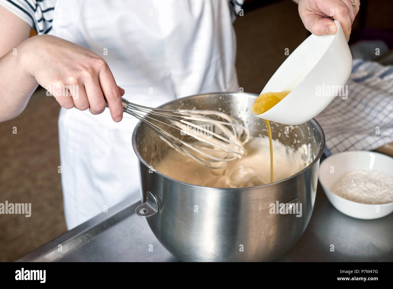 Steps to make a raspberry cake, adding liquid butter to the dough Stock ...