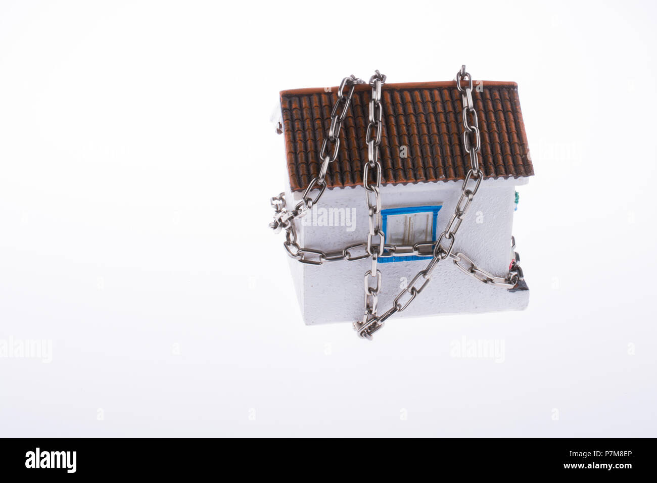 house in chains on a white background Stock Photo - Alamy