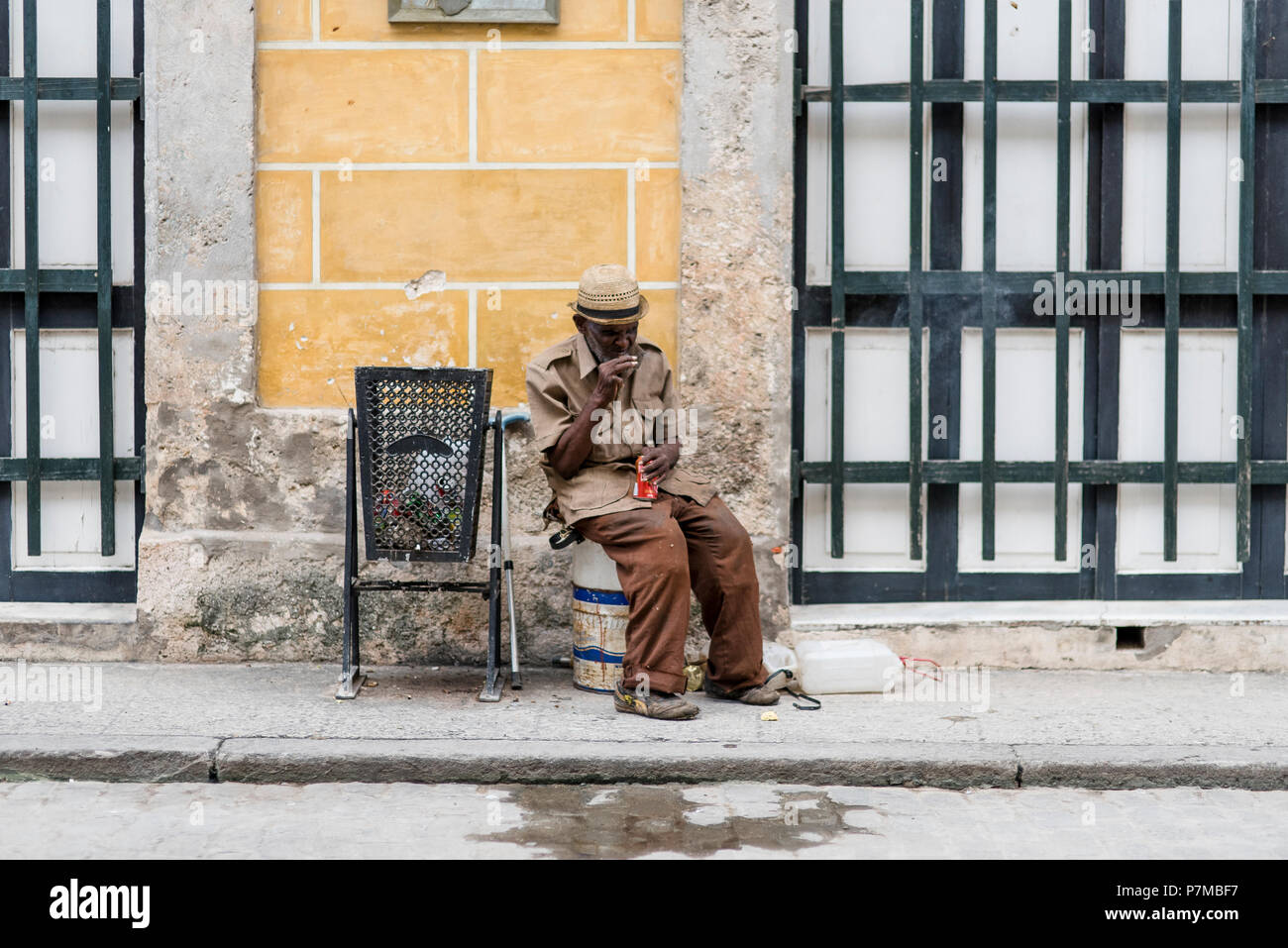 An older man sitting on a barrel in Central Havana Stock Photo - Alamy