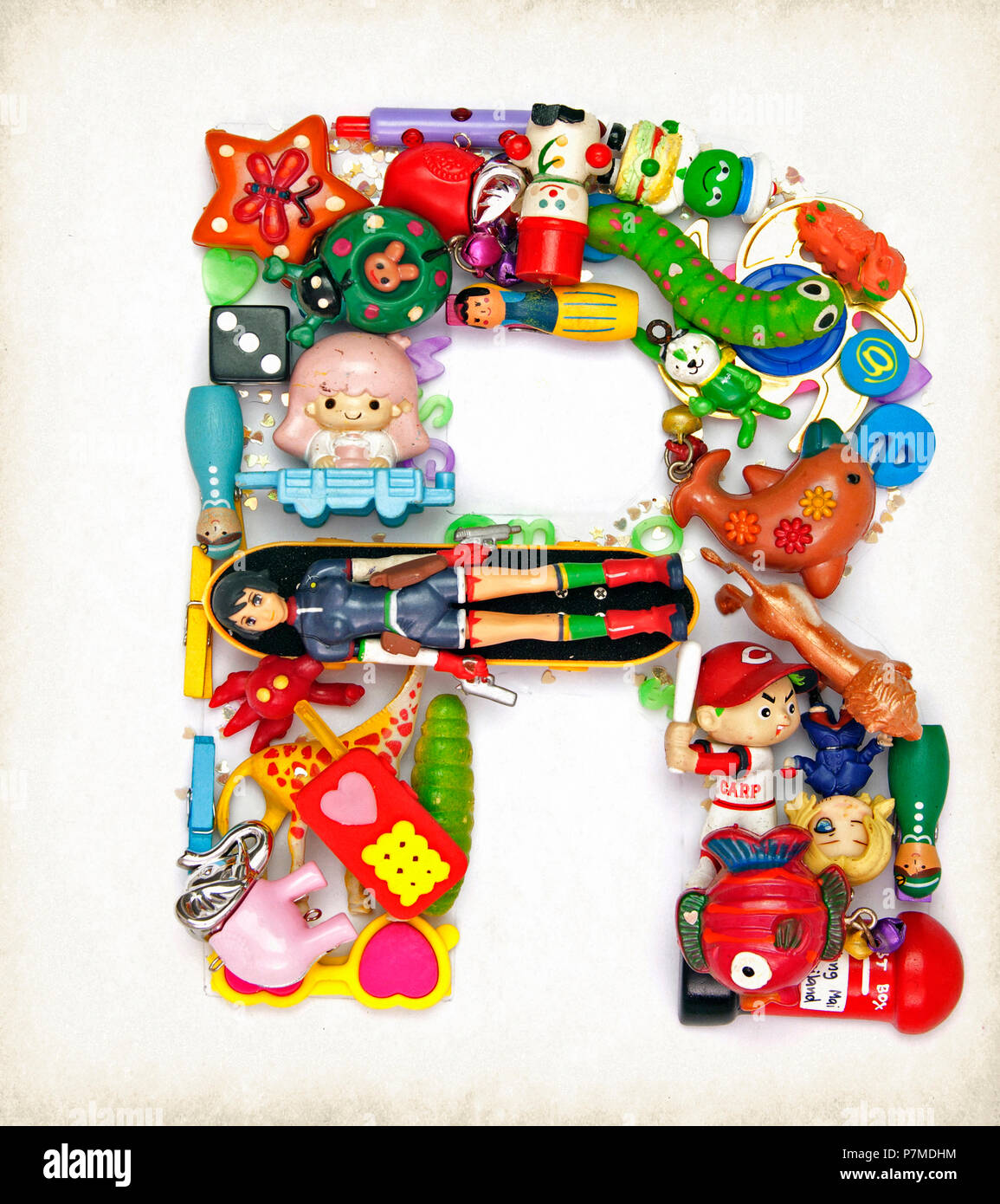 the letter R made from small toys with old paper background bright ...