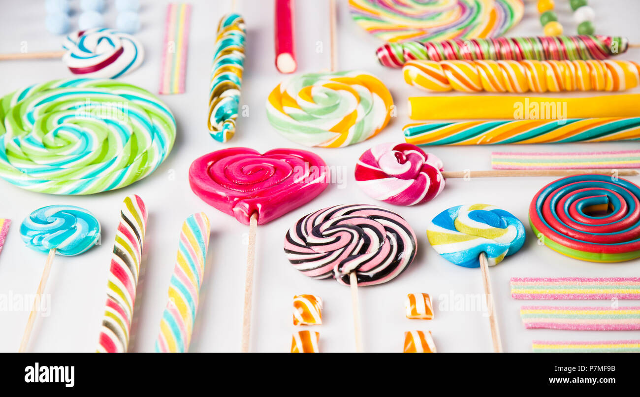 Colorful lollipops and different colored round candy and gum balls ...