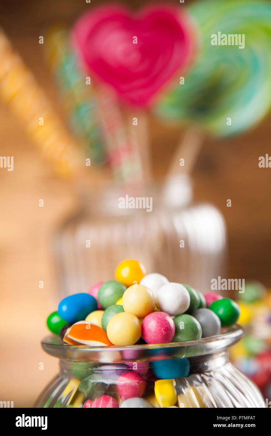 Colorful lollipops and different colored round candy and gum balls ...