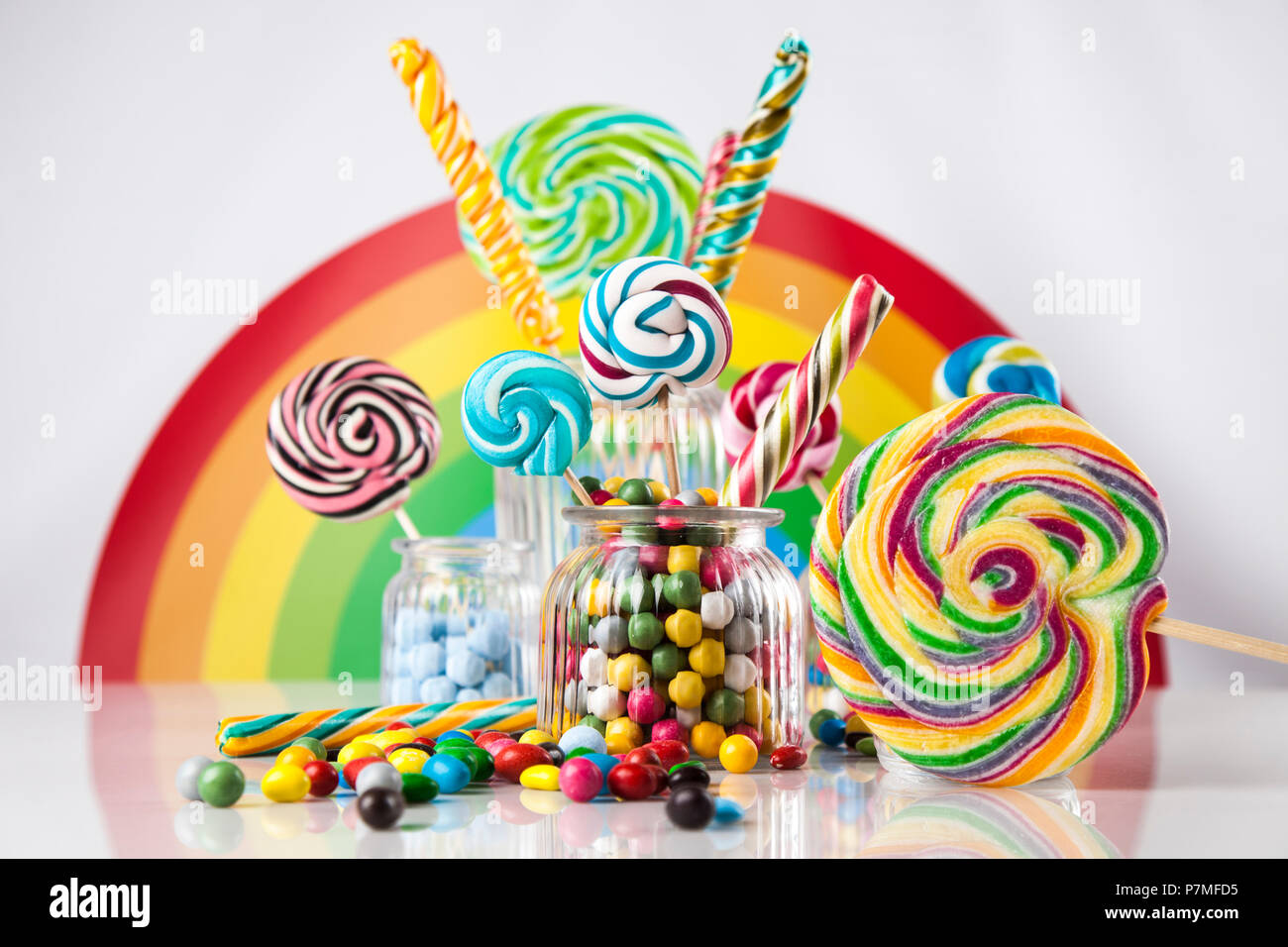 Colorful lollipops and different colored round candy and gum balls ...