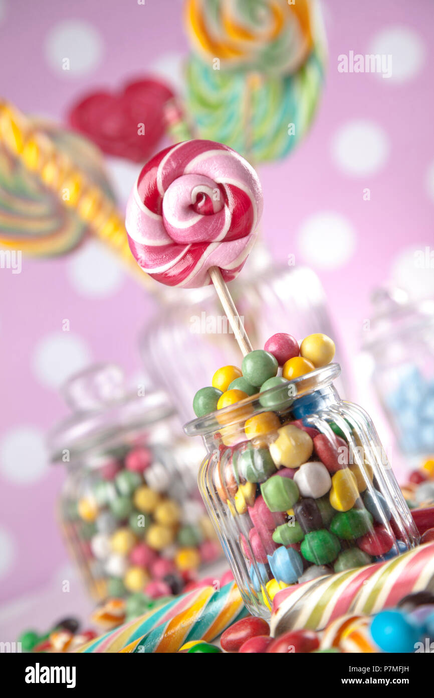 Colorful lollipops and different colored round candy and gum balls ...