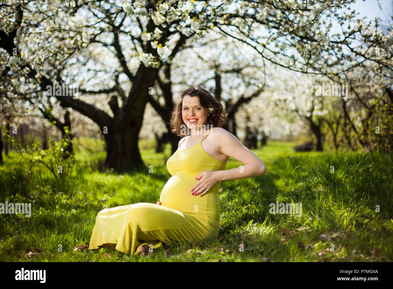 Beautiful pregnant woman relaxing outside in the Orchard Stock Photo ...