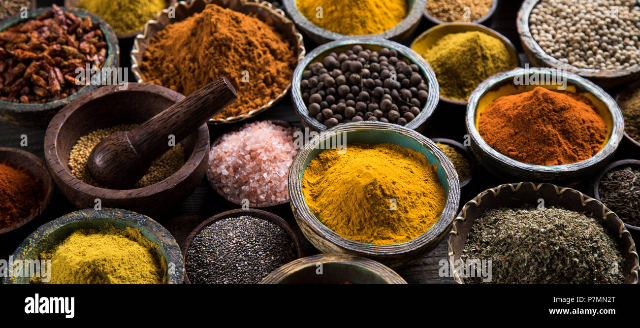 Wooden table of colorful spices Stock Photo - Alamy