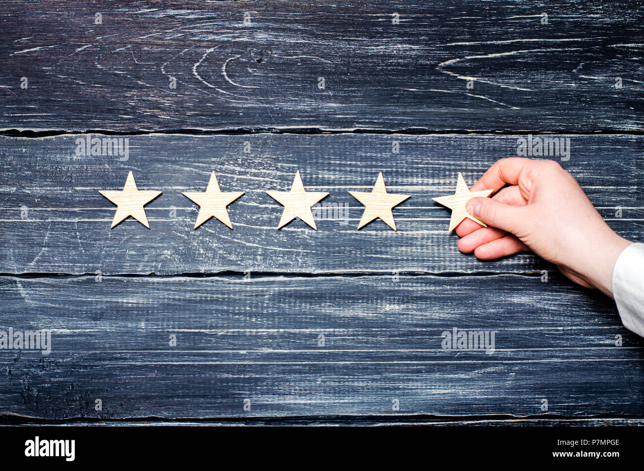 A woman's hand puts the fifth star. Quality status is five stars. A new ...