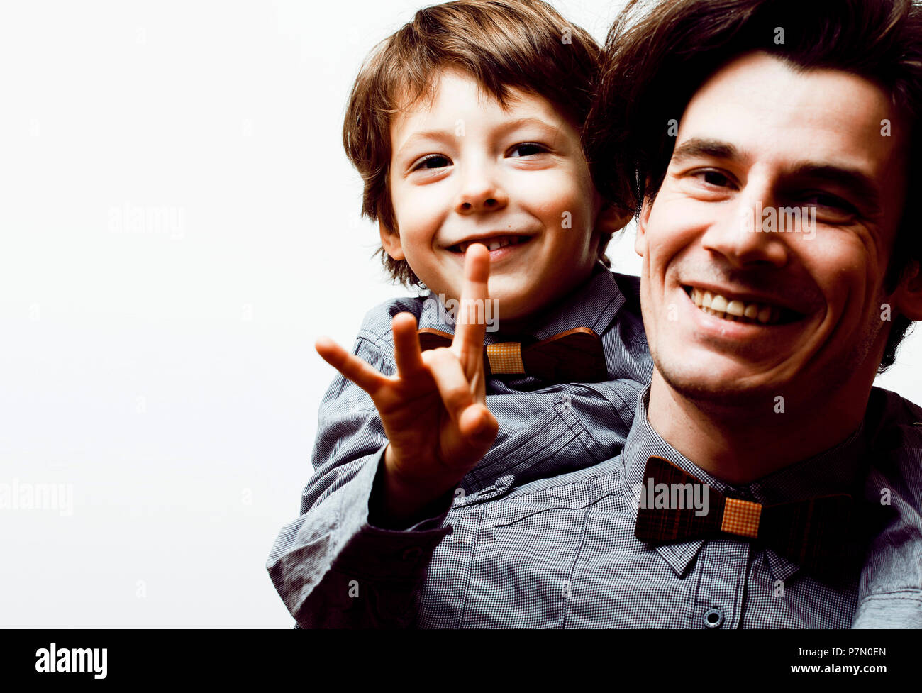 father with son in bowties on white background, casual look family ...