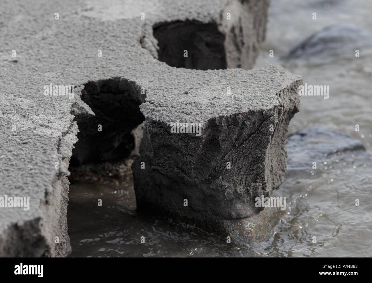 Sand on rock erodes into interesting shapes by tidal water Stock Photo ...