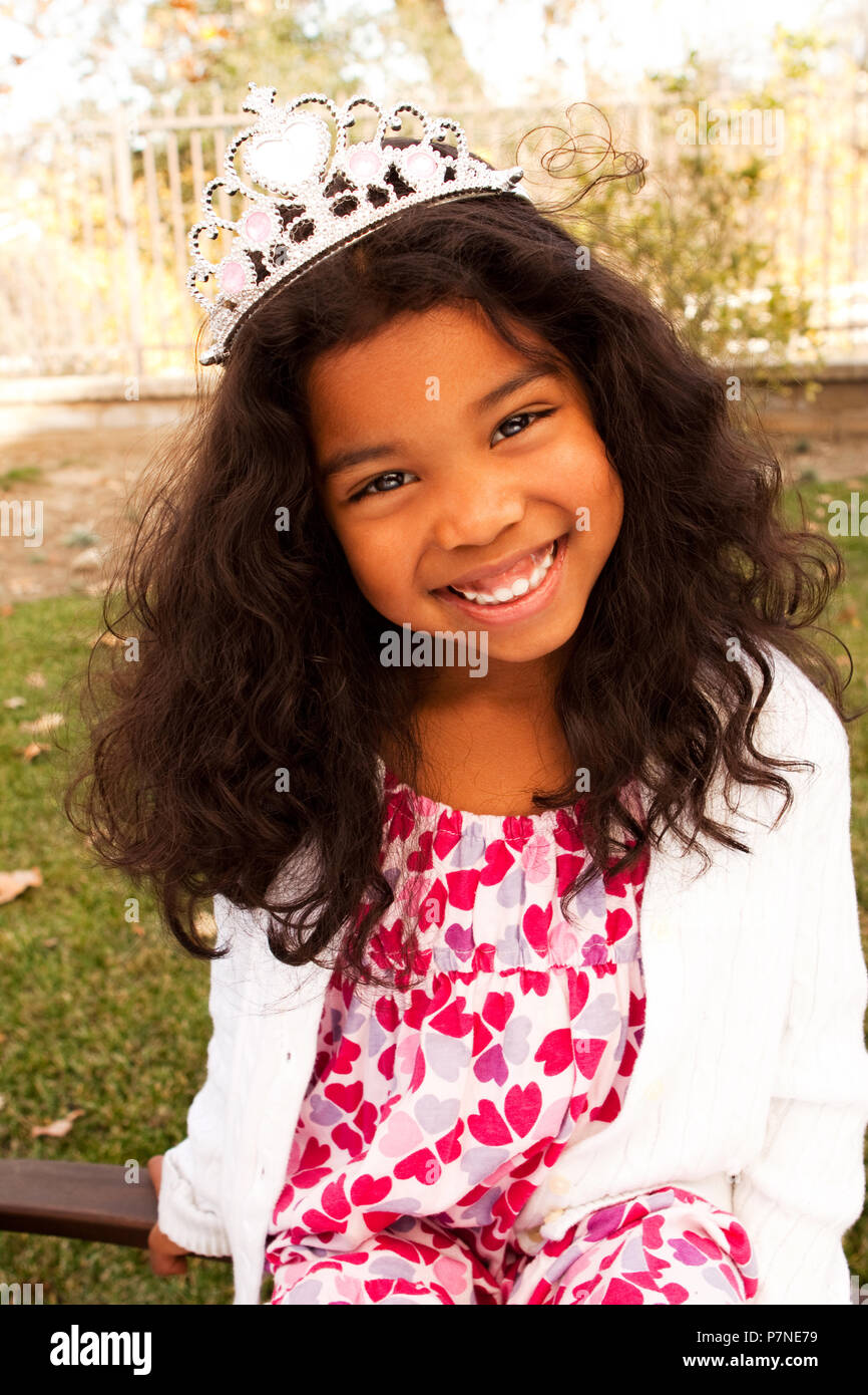 Cute little girl smiling wearing a tiara Stock Photo - Alamy