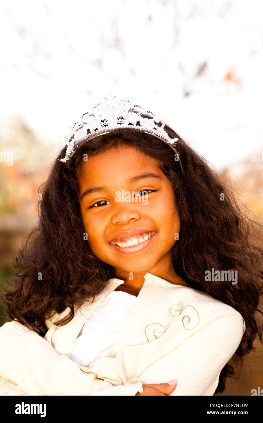 Cute little girl smiling wearing a tiara Stock Photo - Alamy