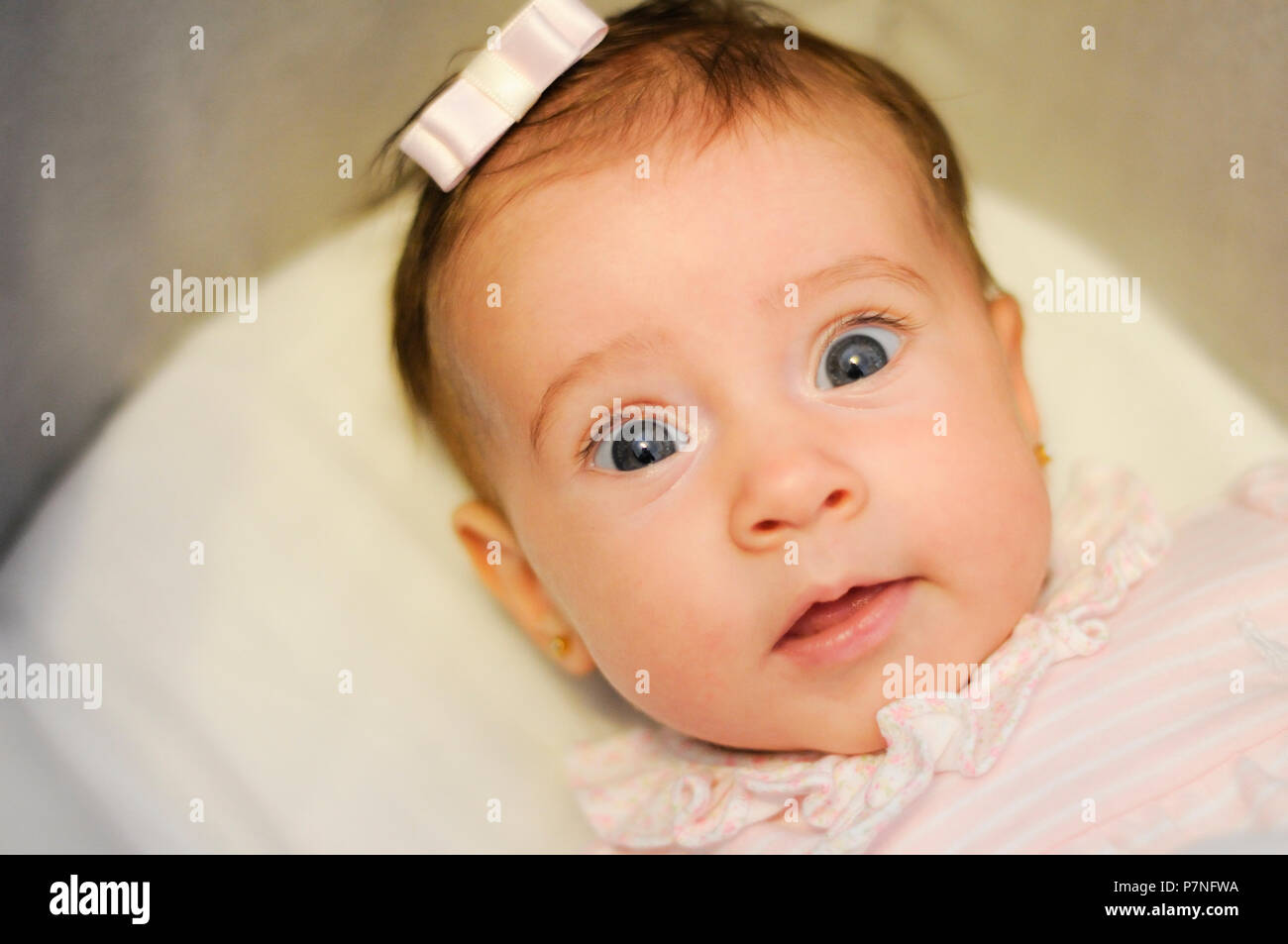 Little baby girl with funny surprise expression on her face. Two months ...