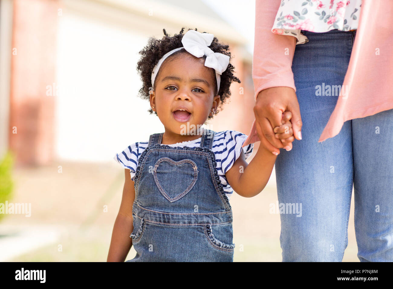 Little girl holding her mothers hand Stock Photo - Alamy