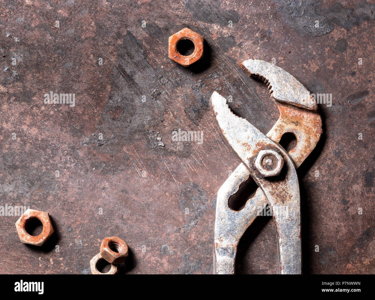 Old rusted tool and screws on grunge texture background. Industrial ...