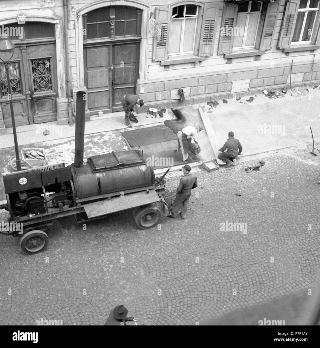 Construction workers repair and tar the pavement, road construction, ca ...