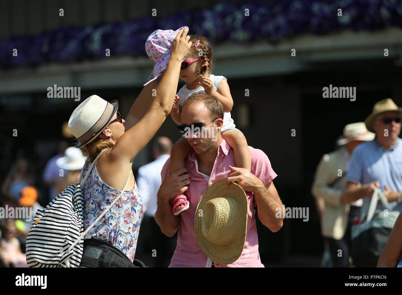 Spectators shield themselves from the sun on day six of the Wimbledon ...