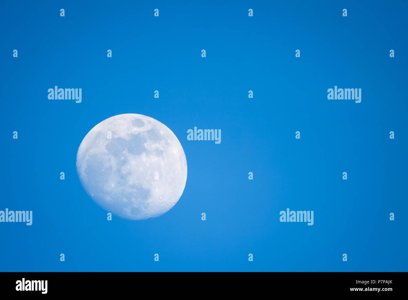 A view of full moon in blue sky background Stock Photo - Alamy