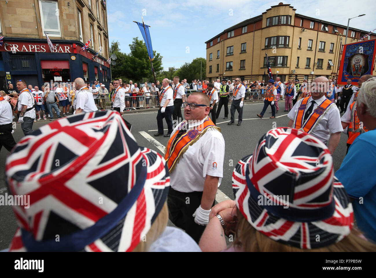 Spectators watch members of the Orange Order take part in the annual ...