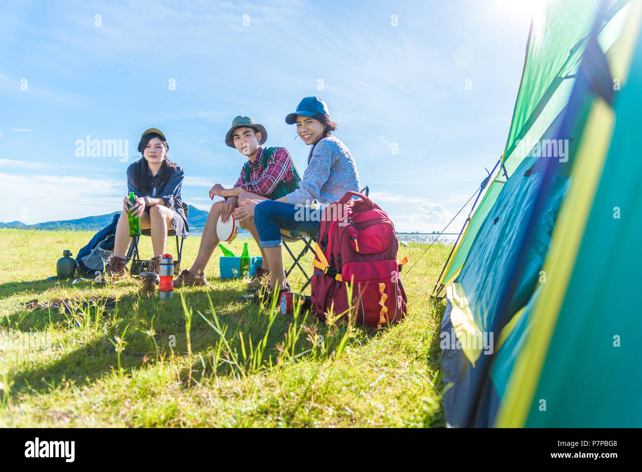 Group of travelers camping and doing picnic in meadow with tent ...