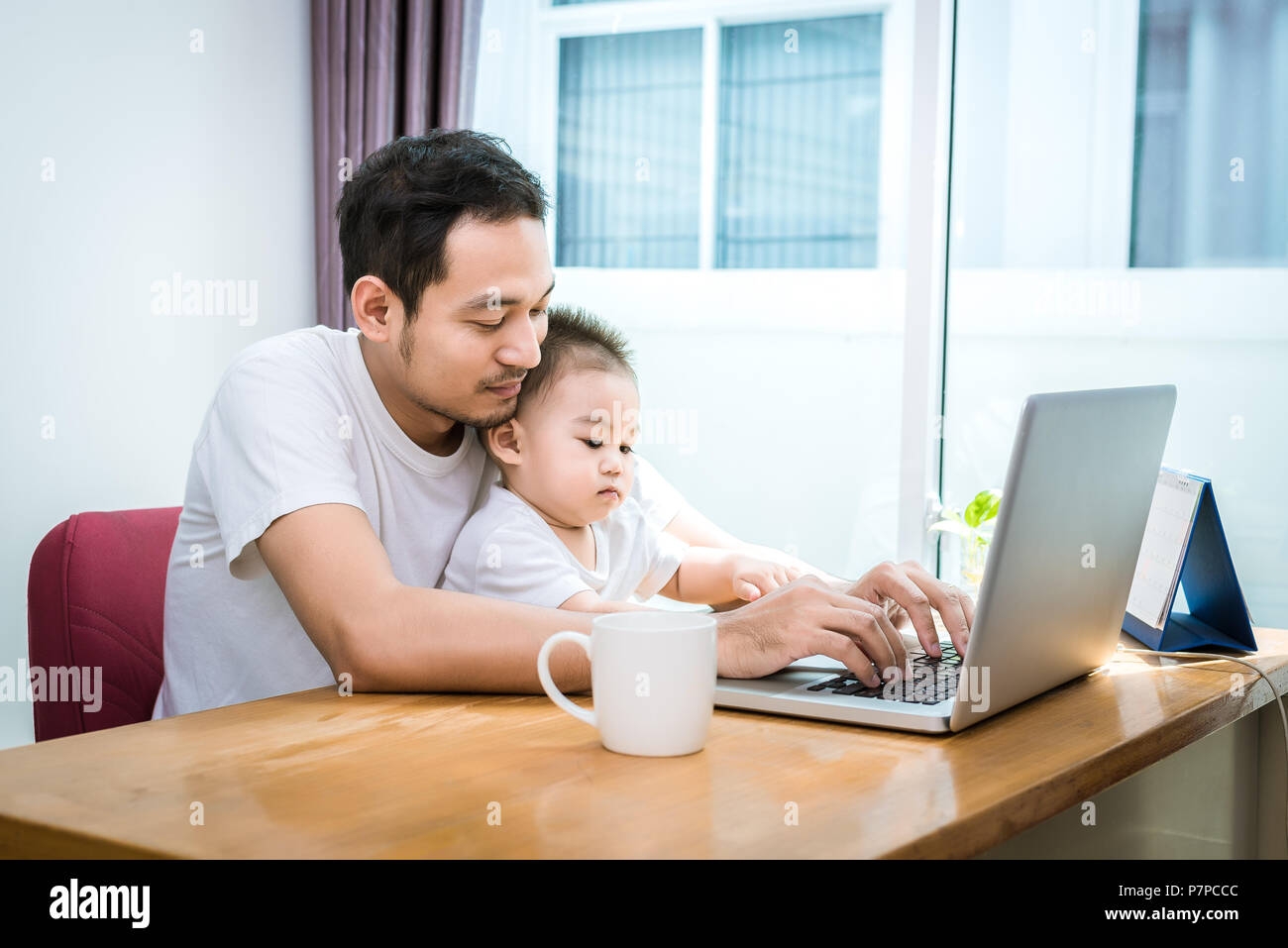 Single dad and son using laptop together happily. Technology and ...