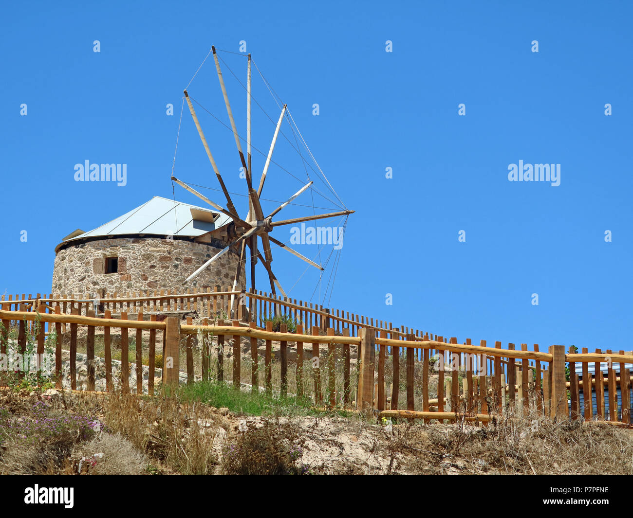 traditional old windmill behind wooden fence in greece Stock Photo - Alamy