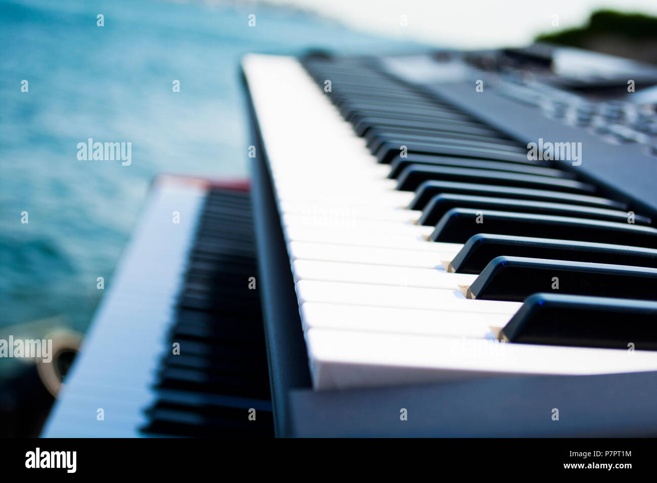 piano keyboard and ocean or sea in the background Stock Photo - Alamy