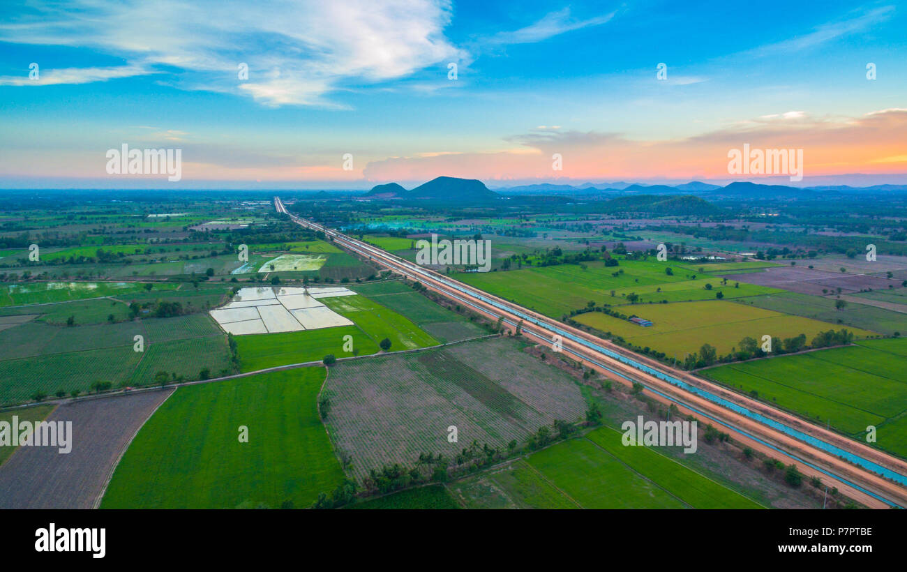 aerial view scenery sunset on new route pass in the rice field. under ...